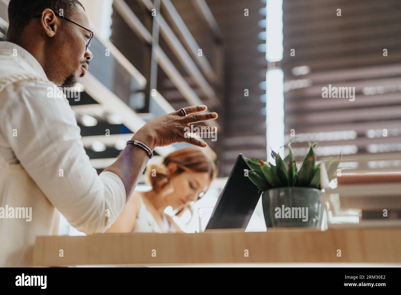 Adult professionals in a corporate office collaborating on projects ...