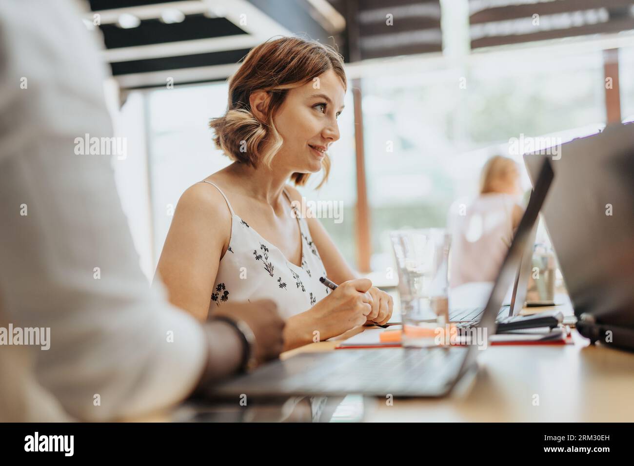 In a vibrant office, a diverse group works together discussing ideas ...