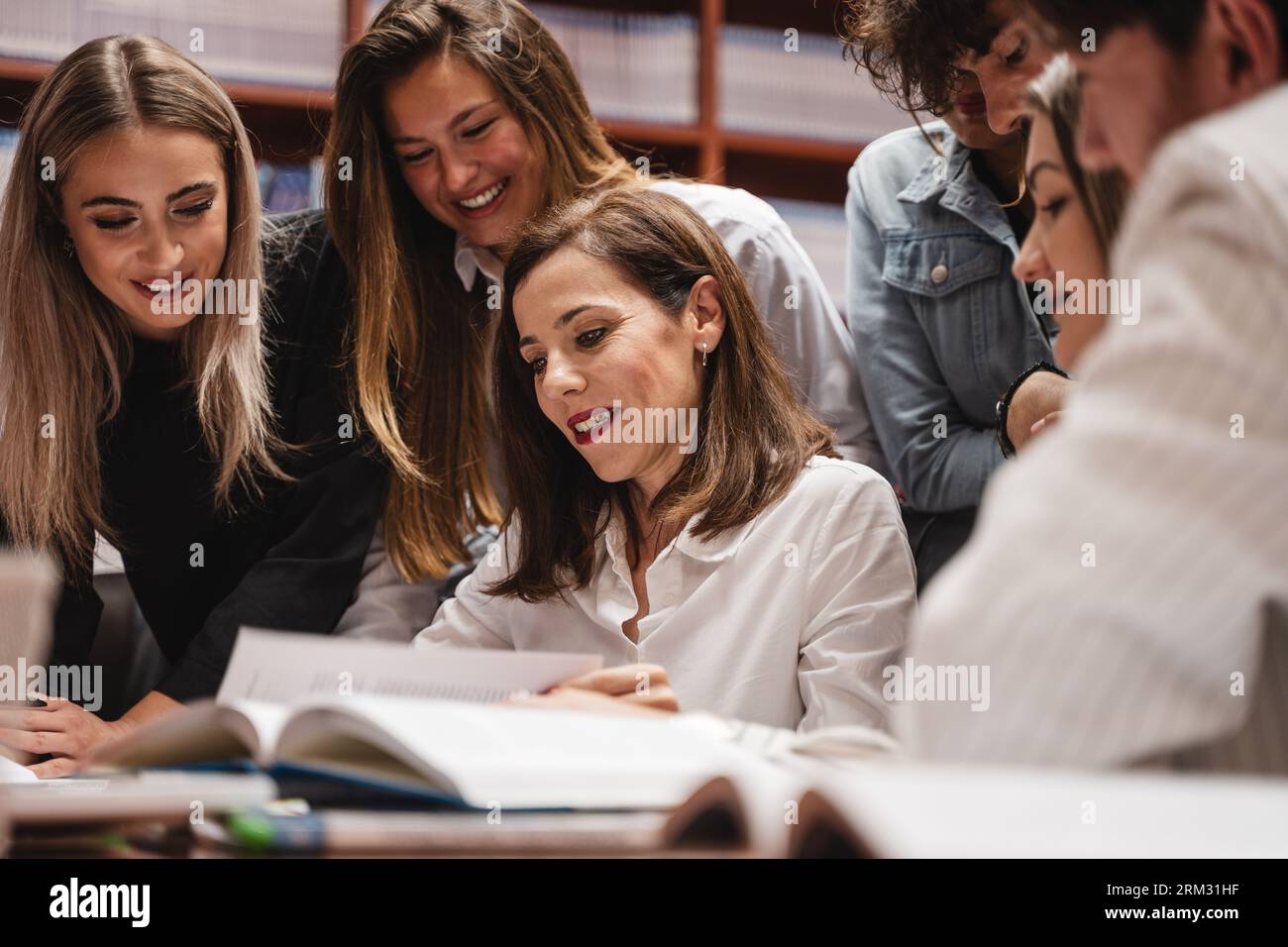 Female professor explaining and clarifying to a young group of students ...