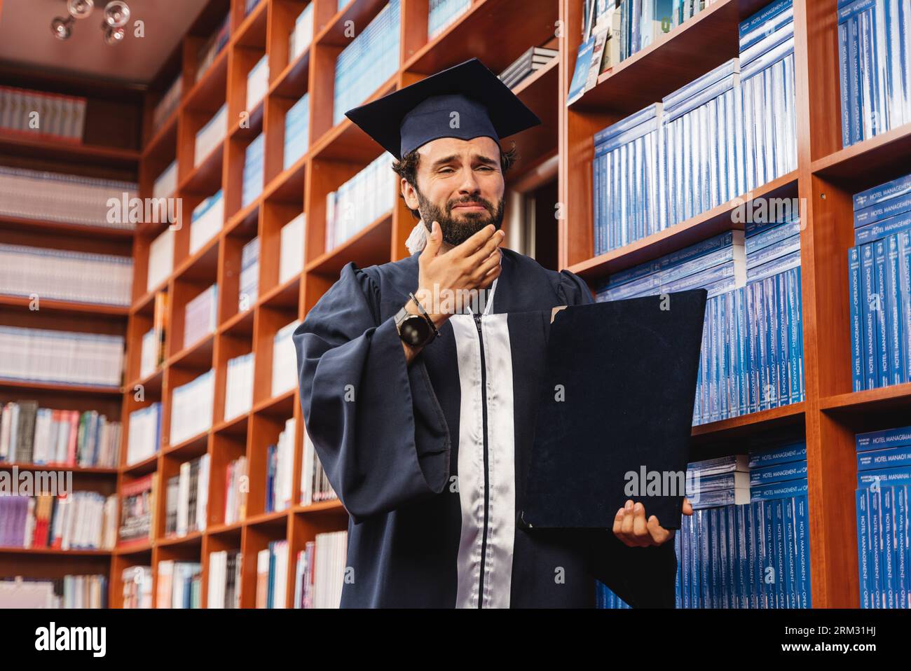Sad college graduate holding diploma hi-res stock photography and ...