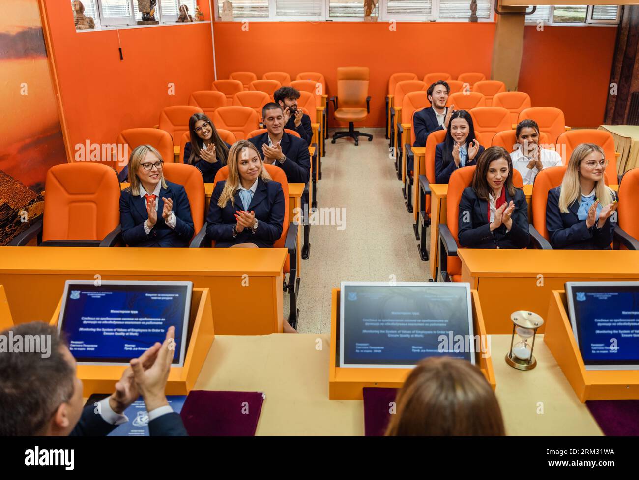 Professors and students applauding their classmate after giving a ...