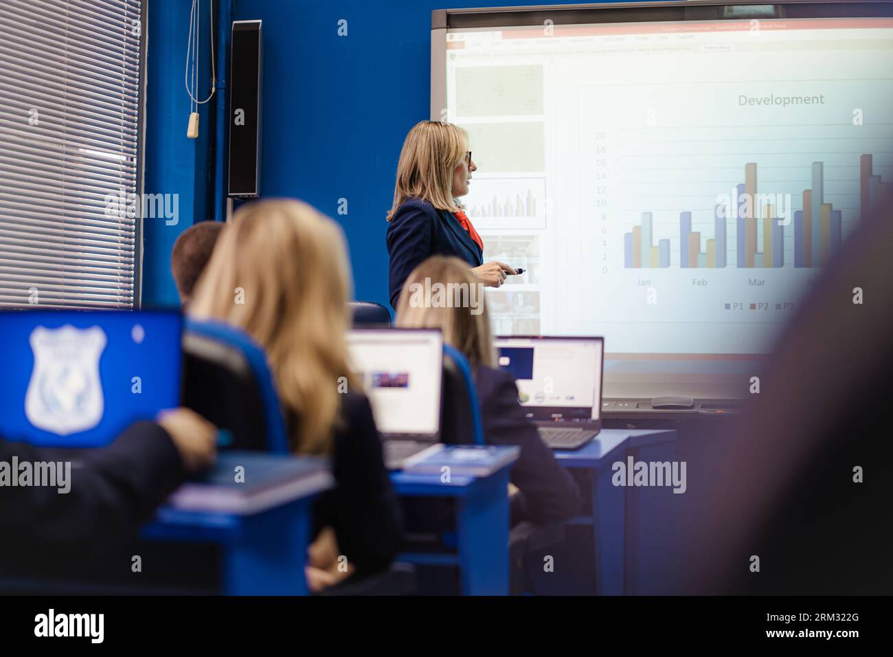 Professor presenting and giving a lecture about graphs to her students ...
