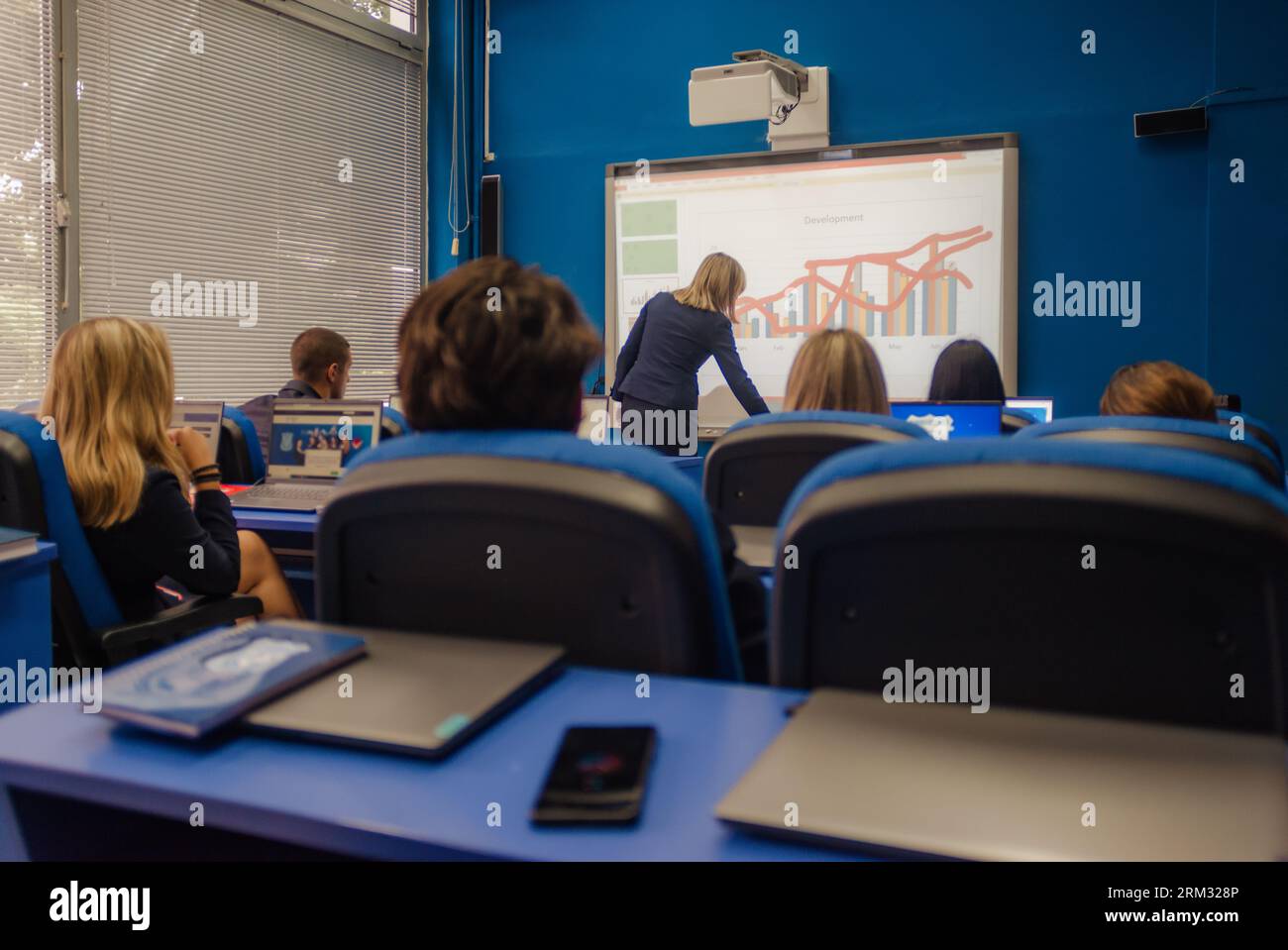 Concentrated students listening to their professor explaining new ...