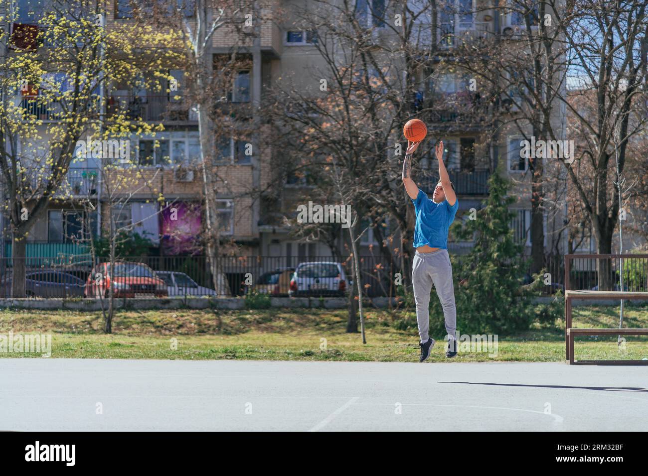Good looking male basketball player shooting for 3 points. Training at ...