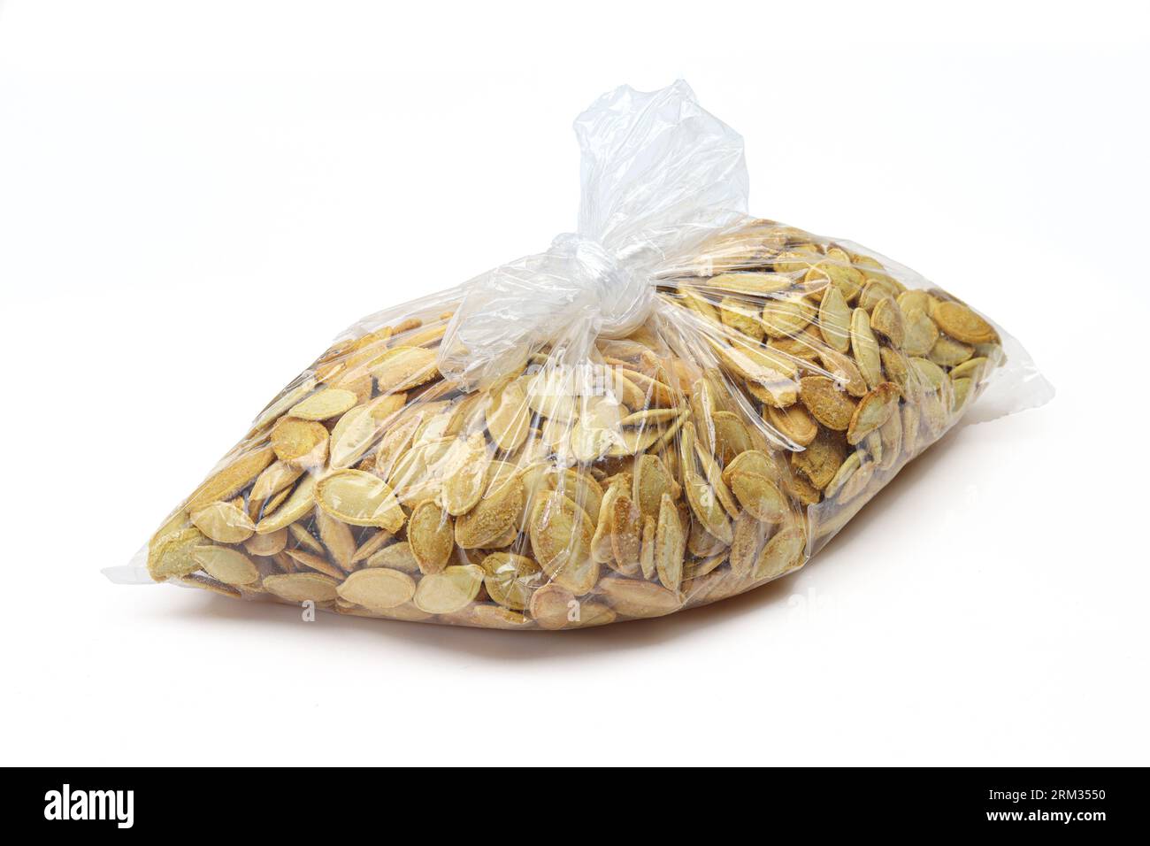 Salty roasted pumpkin seeds in plastic bag isolated on whie background ...