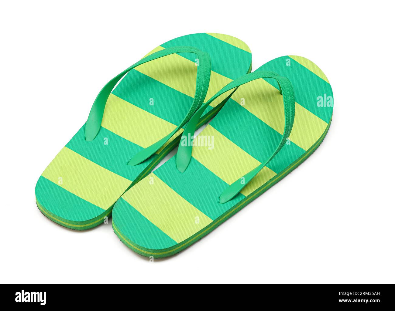 Pair of striped flip-flops in green yellow colours isolated on white ...