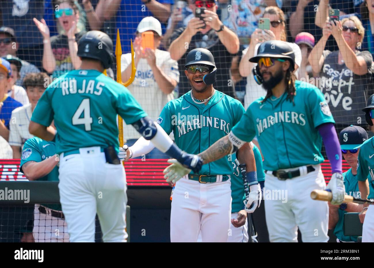 Seattle Mariners' Julio Rodriguez, center, holds a trident for Josh ...