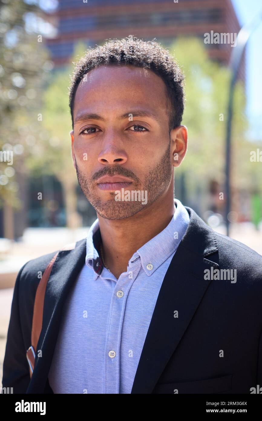 Vertical portrait of young adult Latino business man with serious ...
