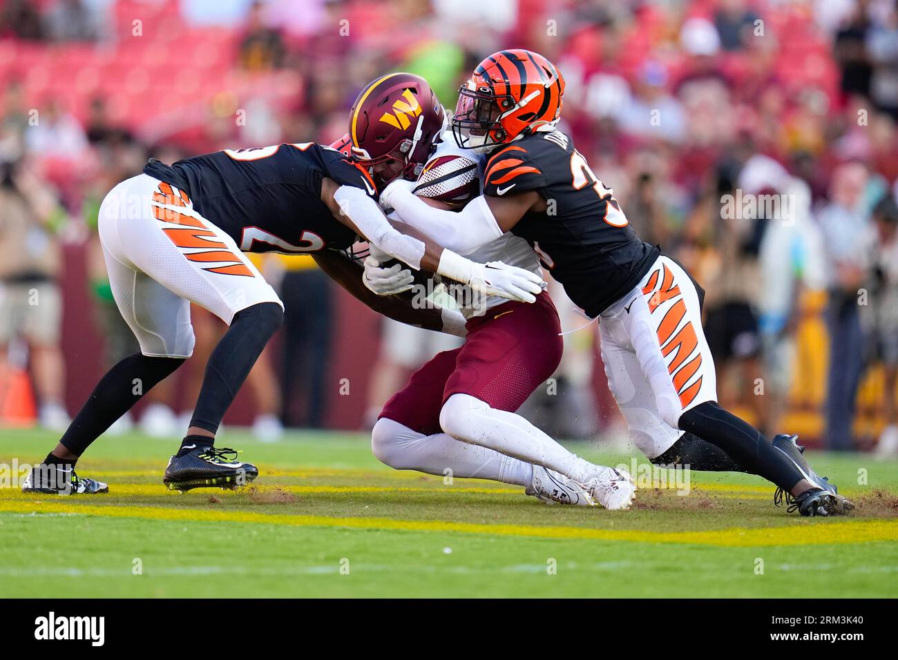 Washington Commanders wide receiver Dax Milne (15), center, is tackled ...