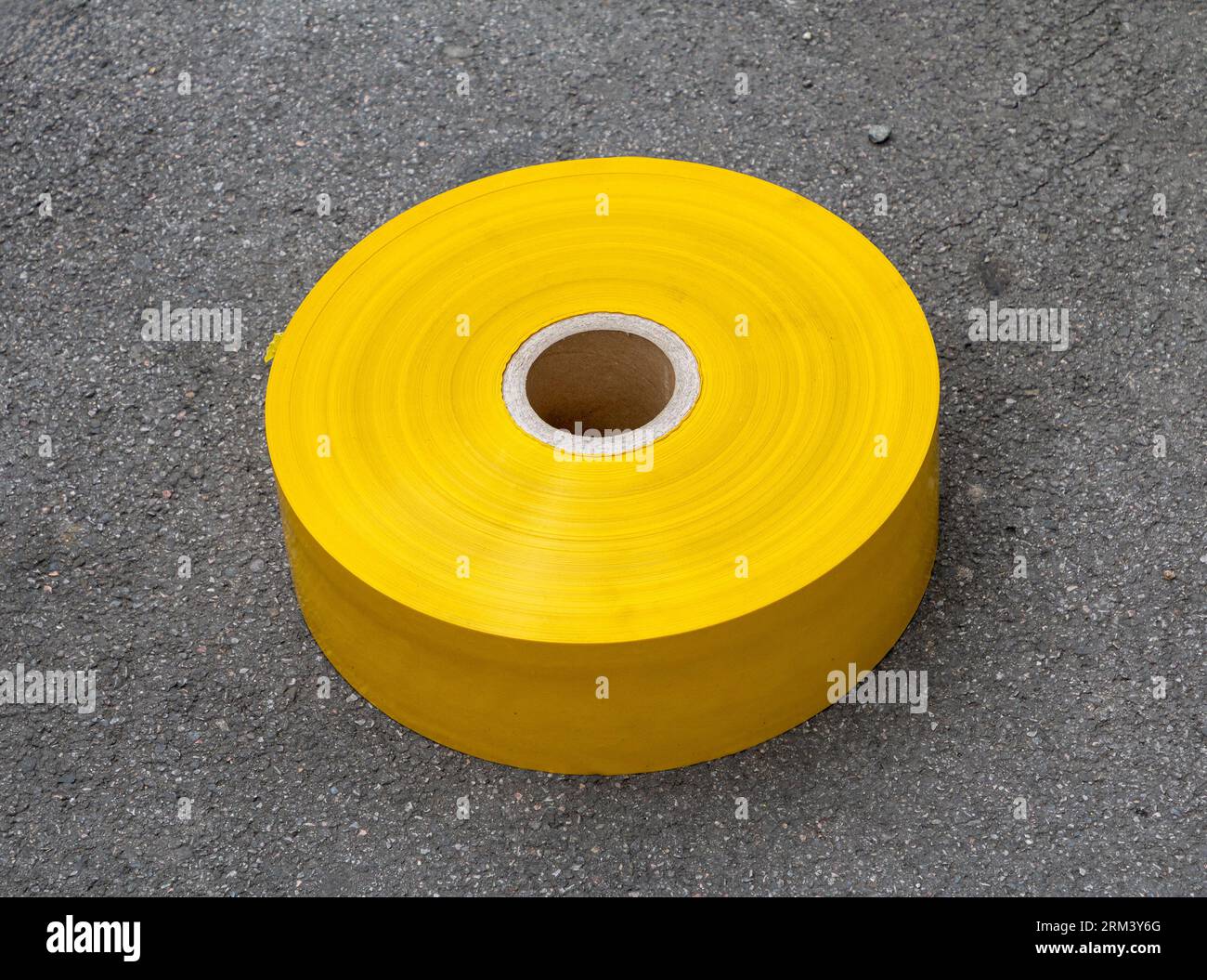 Yellow safety roll tape standing outside on the ground Stock Photo - Alamy