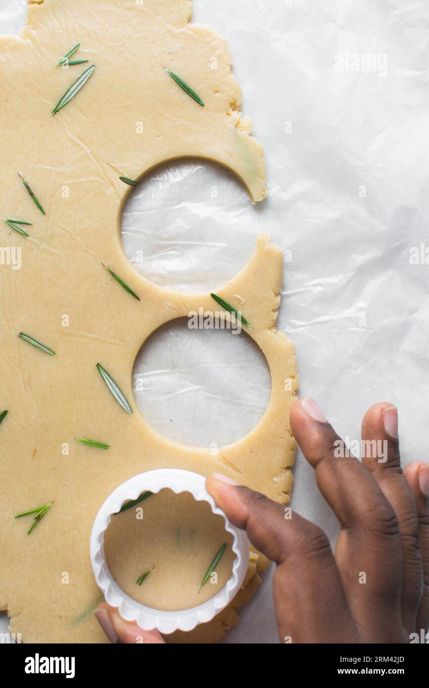 Top view of cutting out rosemary sugar cookie dough, herb cookie dough ...