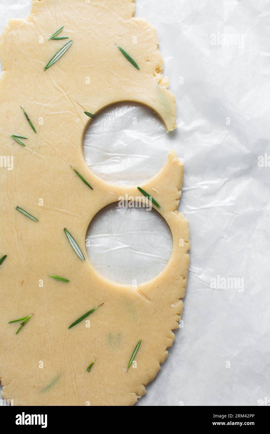 Top view of cutting out rosemary sugar cookie dough, herb cookie dough ...