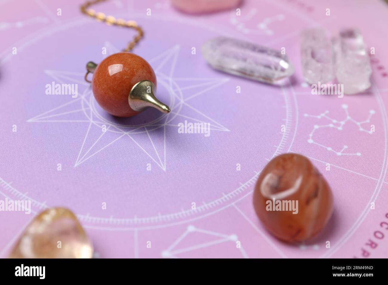 Astrology prediction. Zodiac wheel, gemstones and pendulum, closeup ...