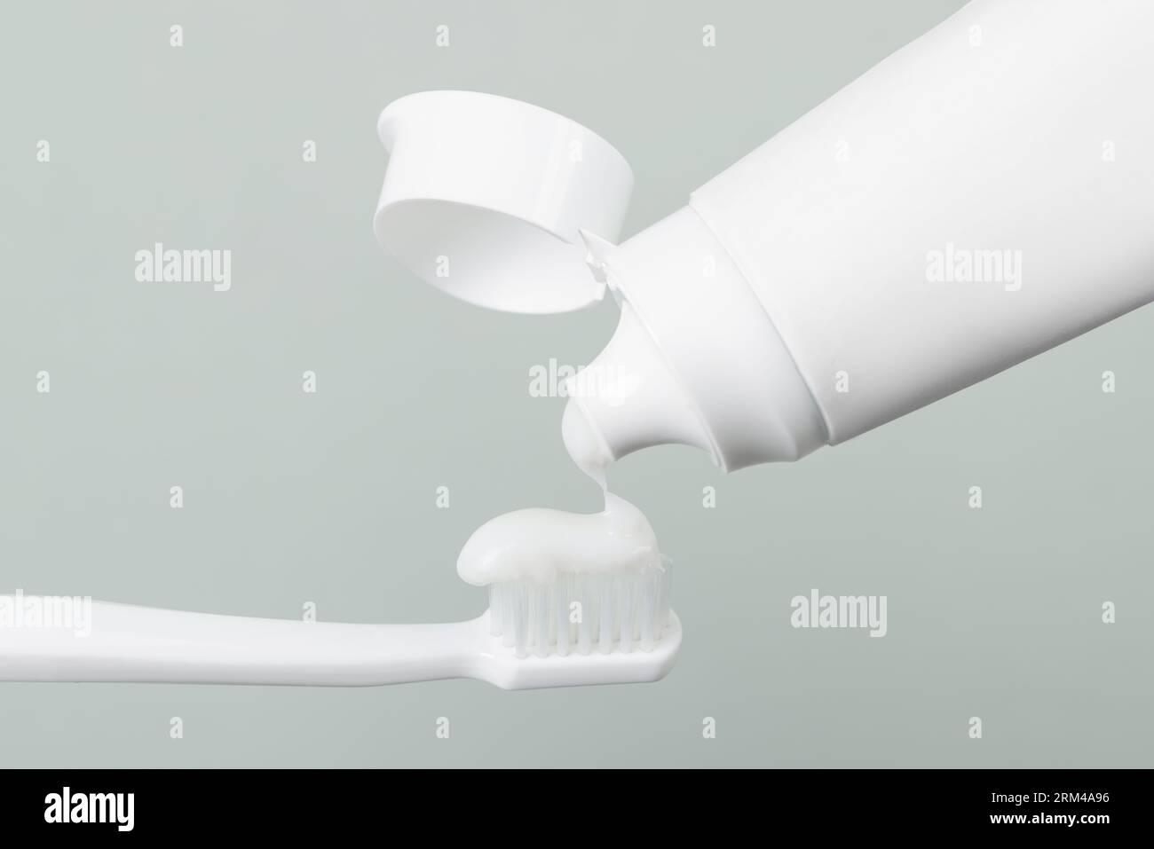 Applying paste on toothbrush against grey background, closeup Stock ...