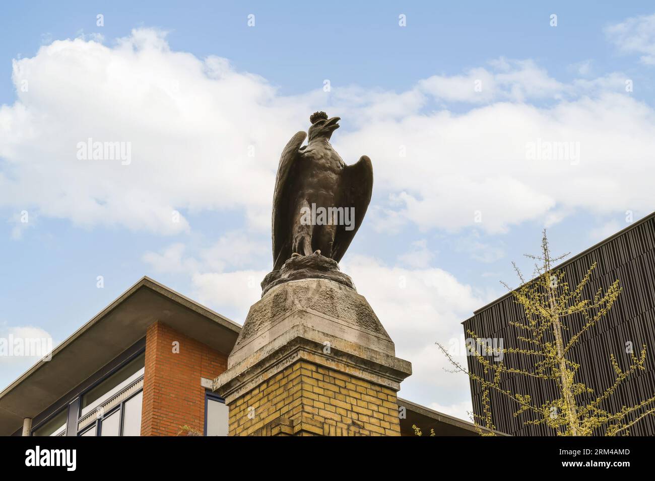 a bird sitting on top of a brick statue in front of a building with a ...