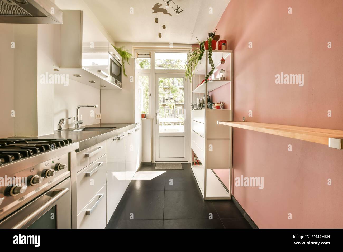 a kitchen area with pink walls and white appliances on the stoves, sink ...