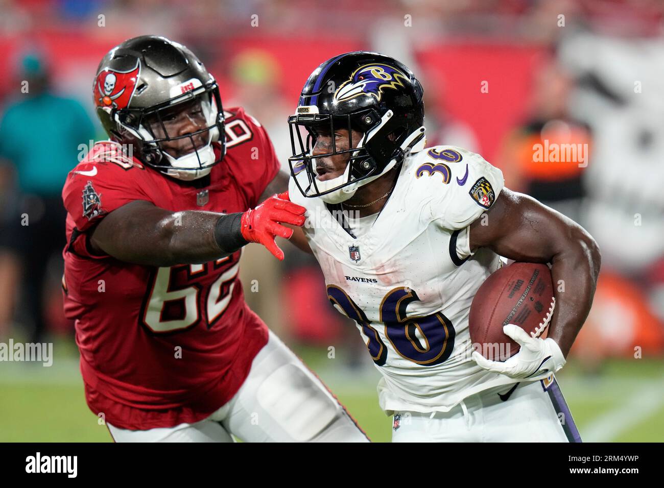 Baltimore Ravens running back Owen Wright, right, avoids a tackle by ...