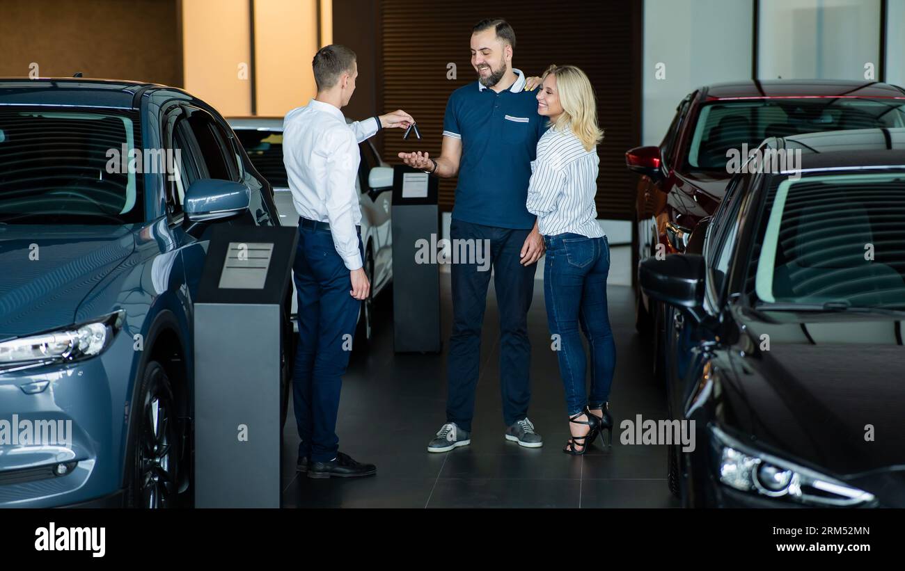 The seller hands over the car keys to the buyers. The couple bought a ...