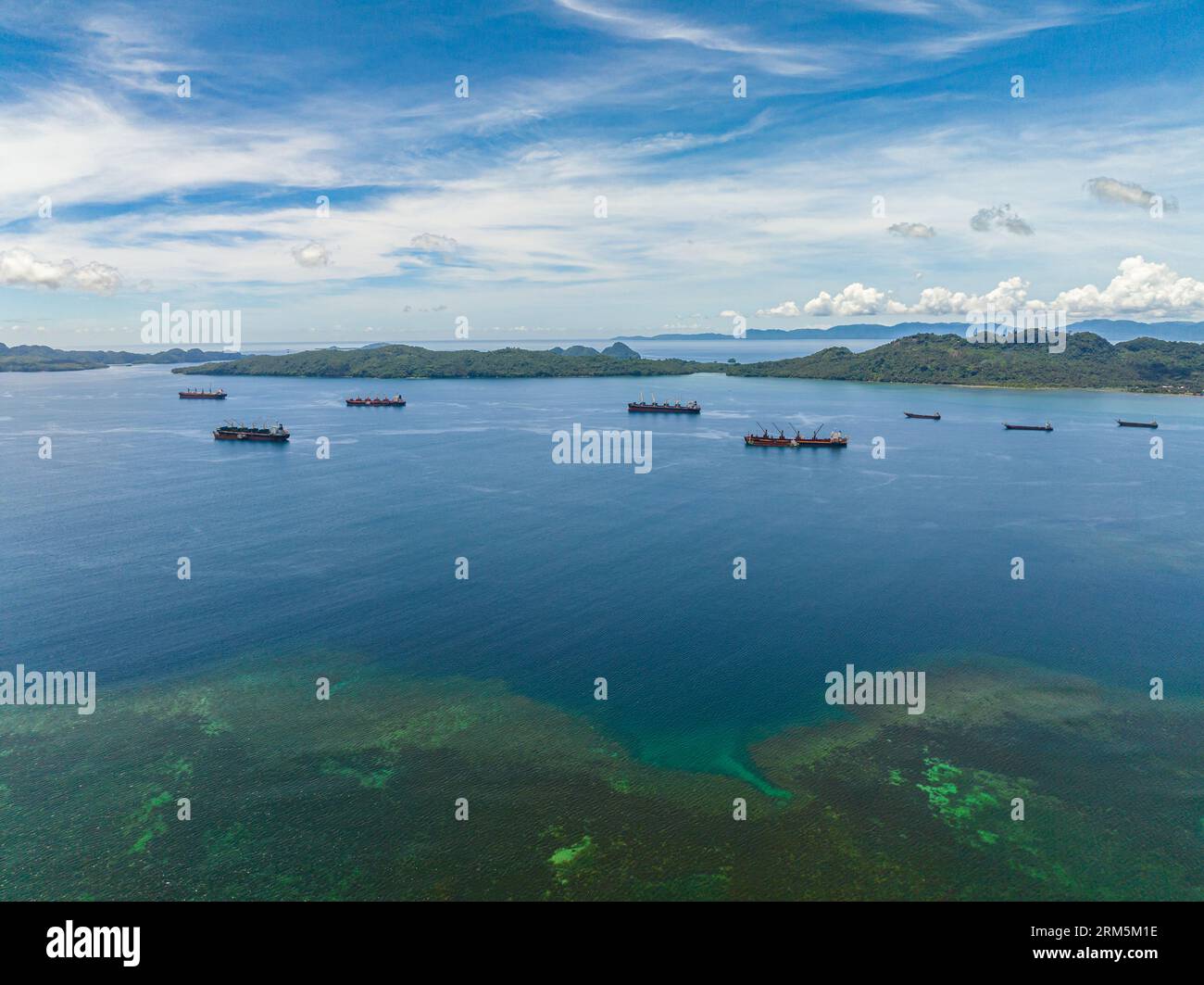Corals in clear sea water. Deep blue sea with merchant and cargo ship ...