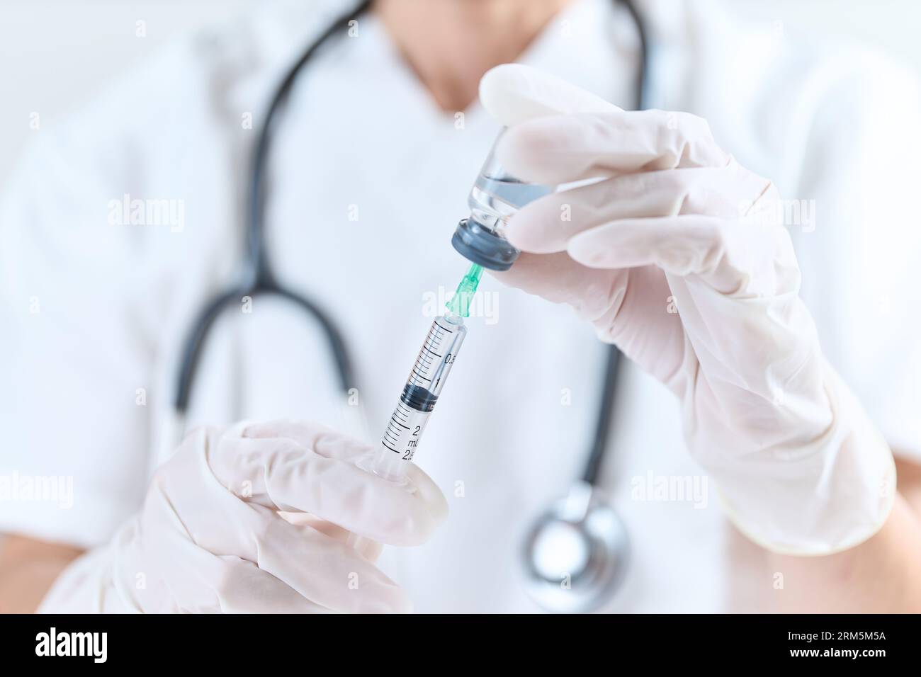 Doctor sucking an injection drug from a vial bottle Stock Photo - Alamy
