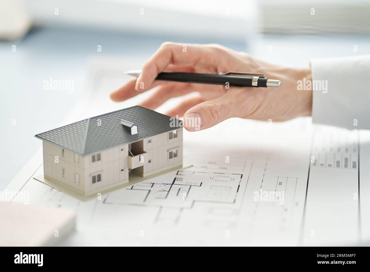 Asian architect writing on building drawings Stock Photo - Alamy
