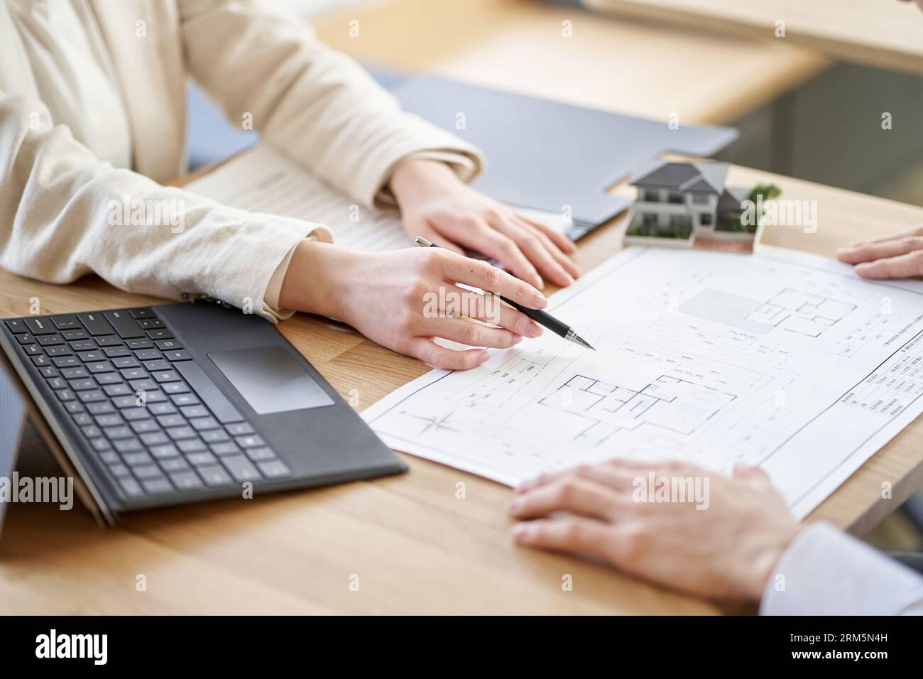 Asian business person having a meeting with the floor plan of real ...