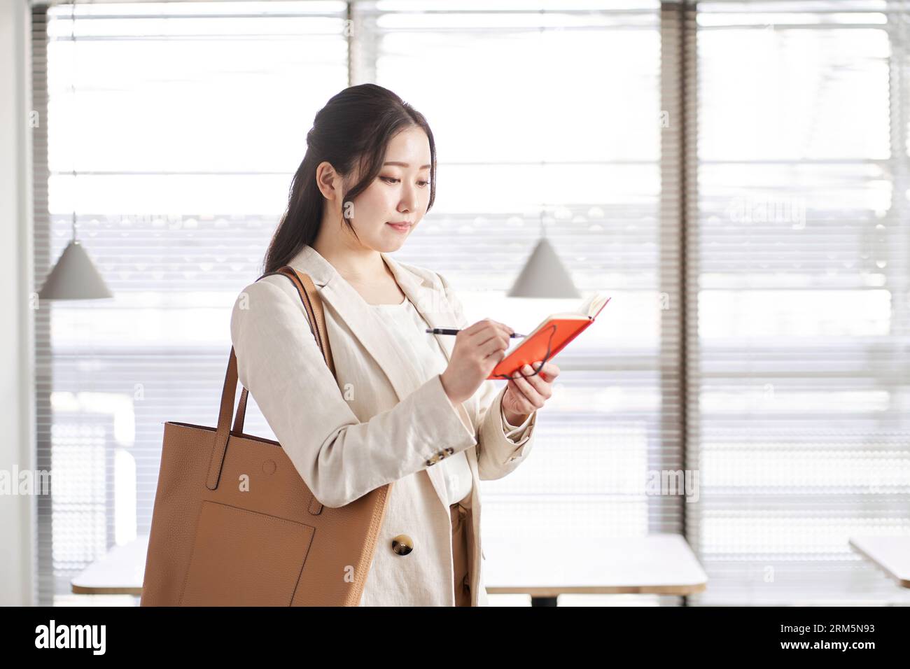 Check notes Asian business woman Stock Photo - Alamy