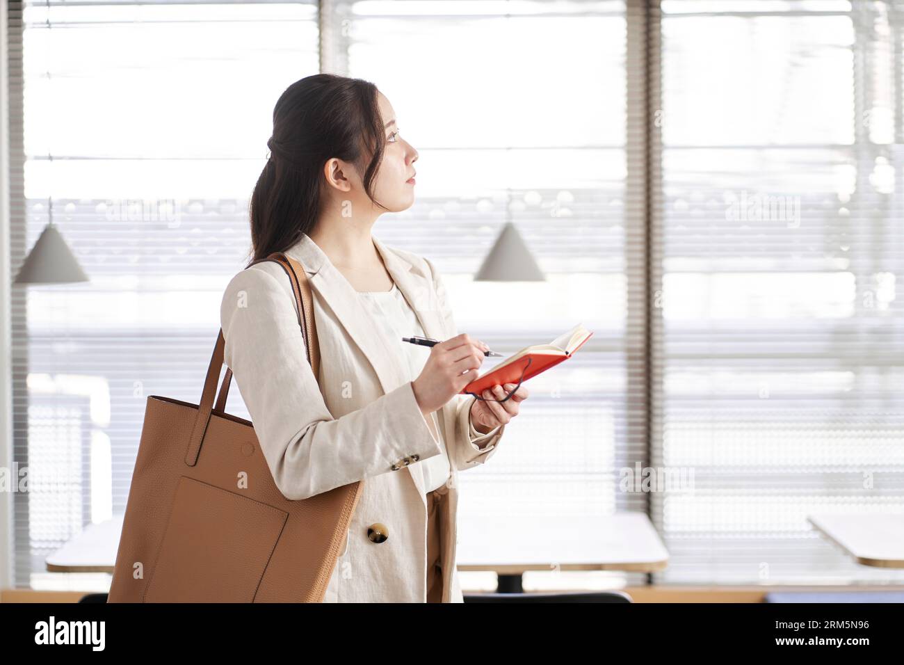 Check notes Asian business woman Stock Photo - Alamy