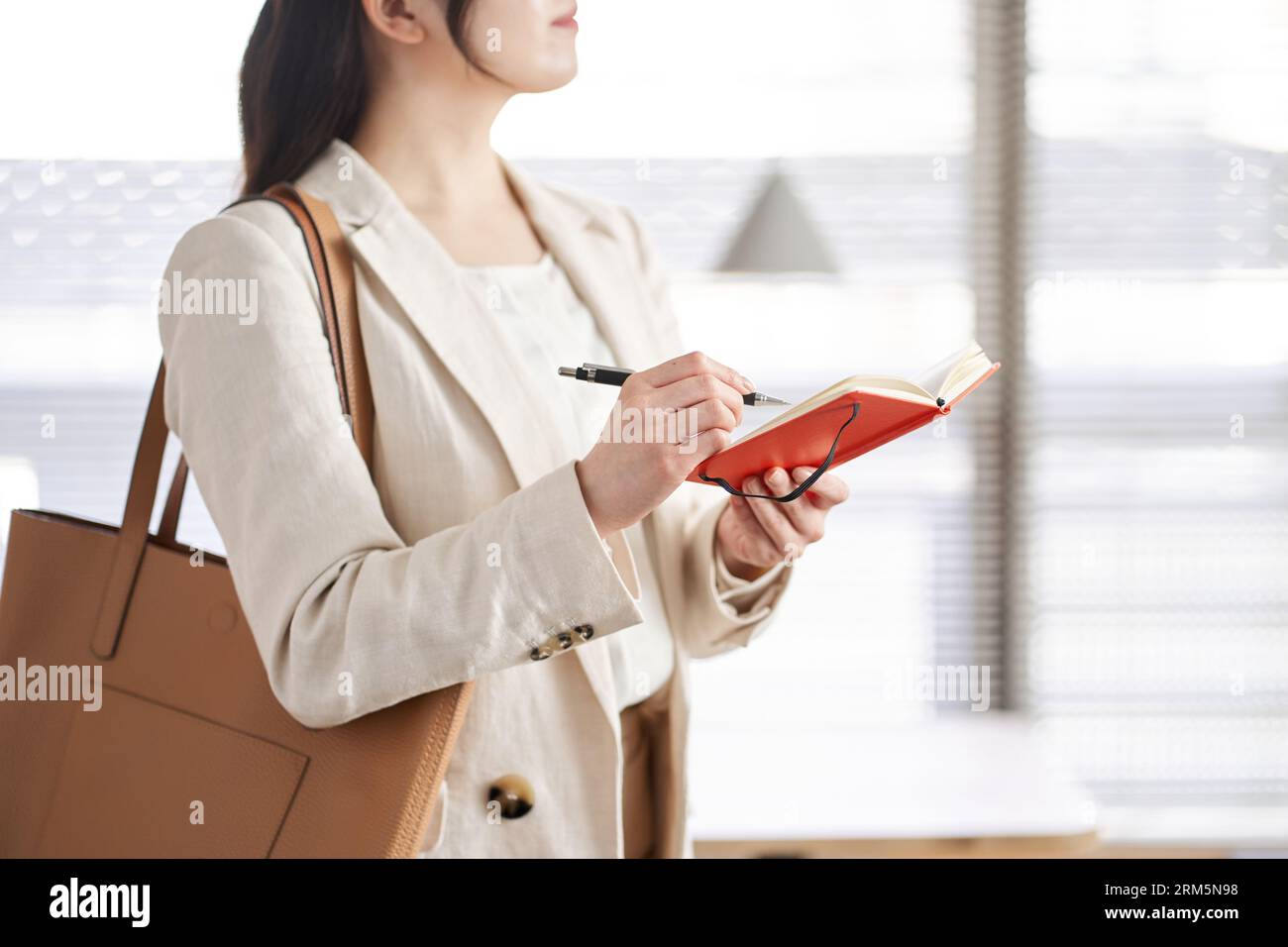 Check notes Asian business woman Stock Photo - Alamy