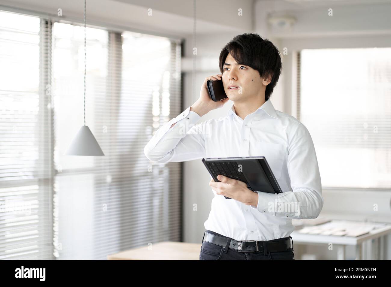 Asian man making phone calls in the office Stock Photo - Alamy