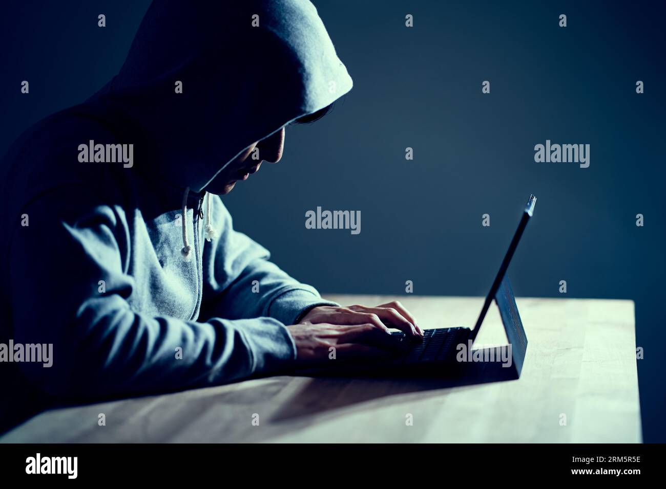 Male hacker writing code on a laptop Stock Photo - Alamy