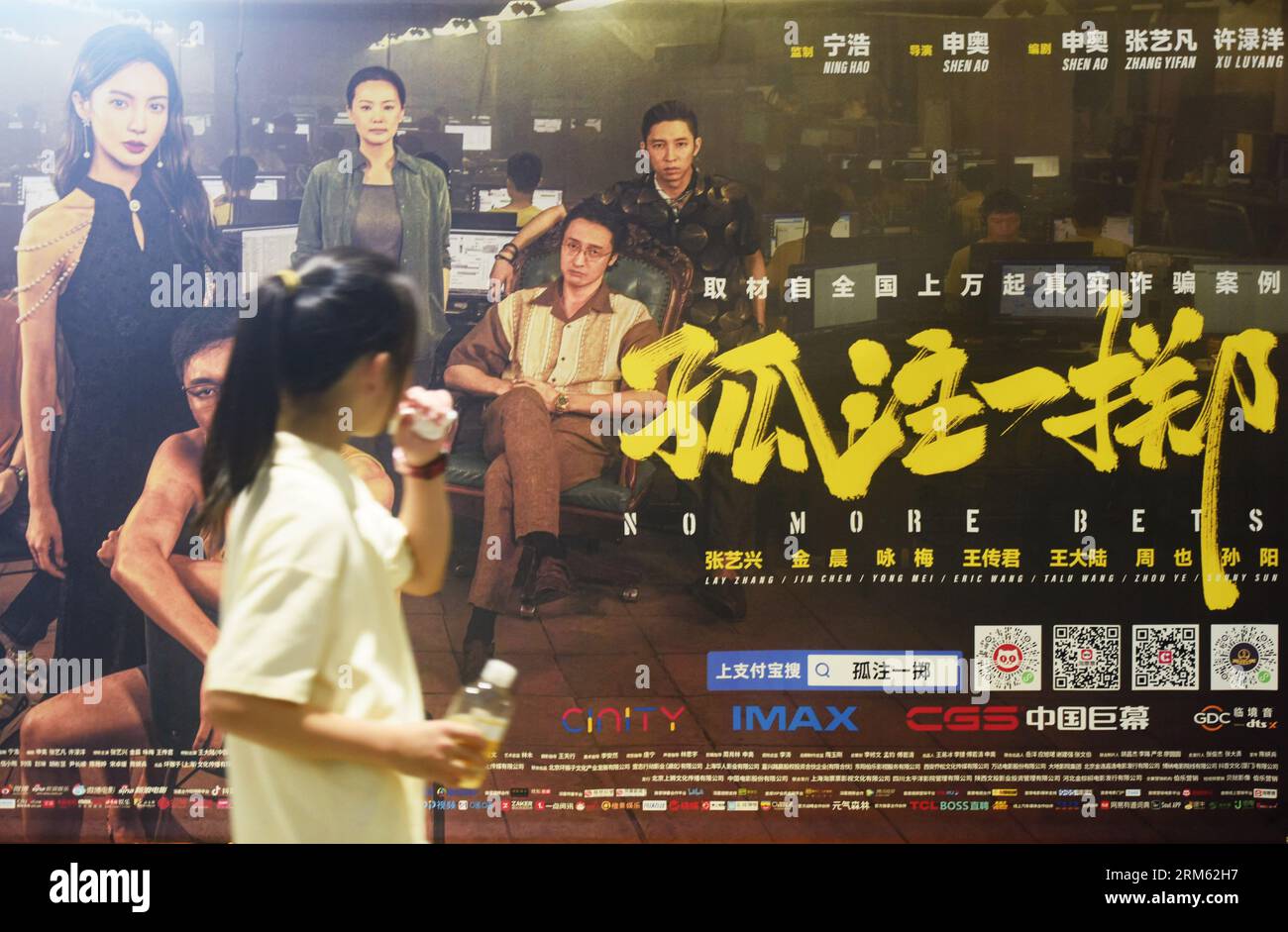HANGZHOU, CHINA - AUGUST 27, 2023 - People walk past a poster of the popular movie "No More Bets ...