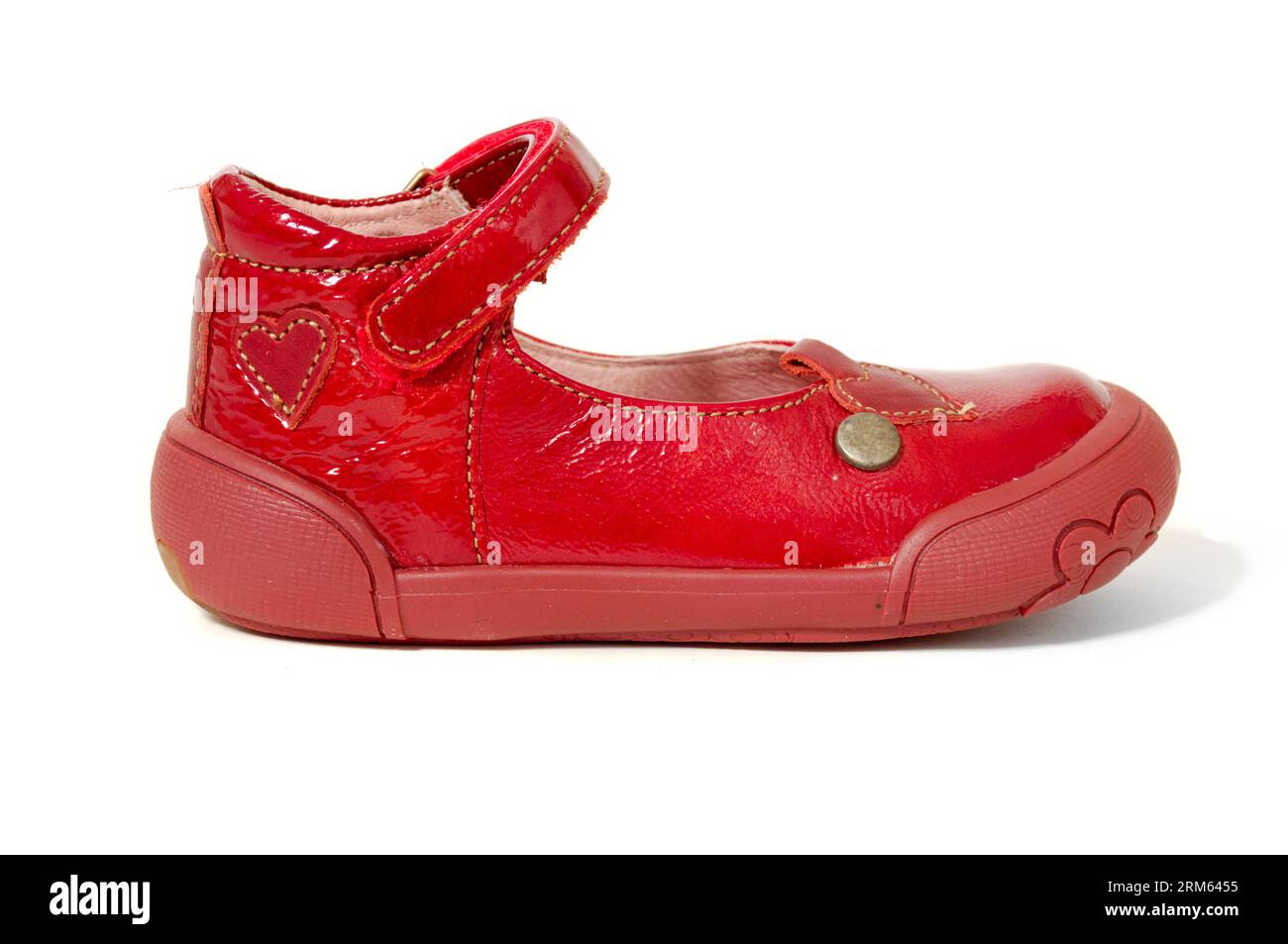 A red childs shoe. Taken on a clean white background Stock Photo - Alamy