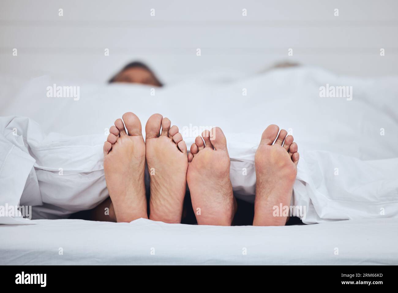 Couple, bed and feet with blanket in sleeping, peace and morning rest ...