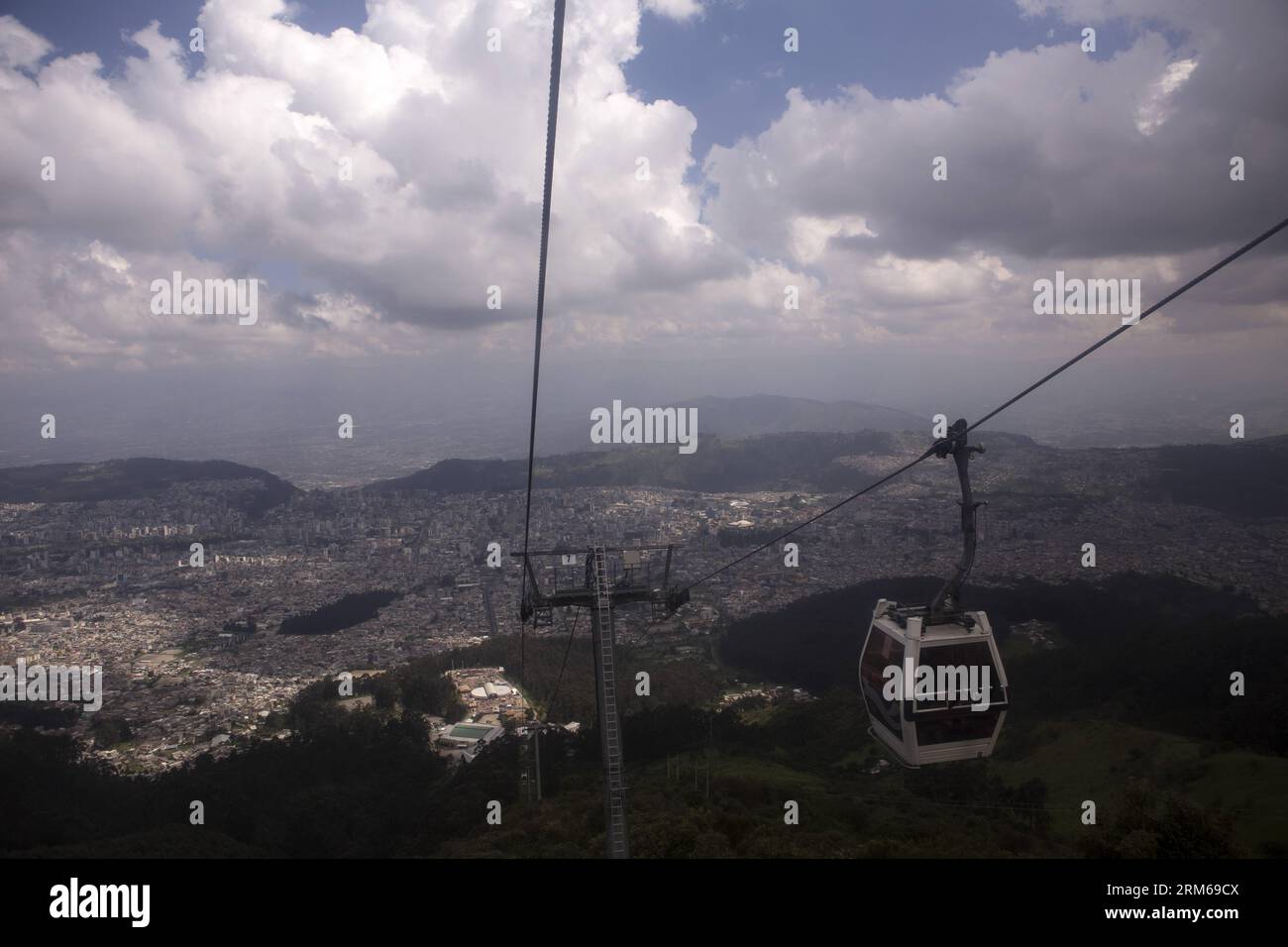 Visitors tour aboard a cable car over the Pichincha Volcano in Quito ...