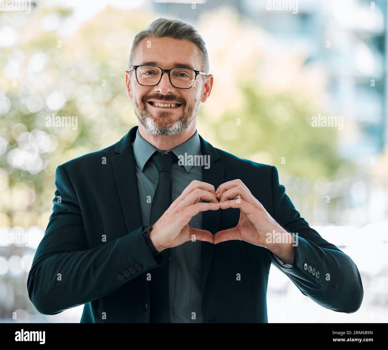 Portrait, business man and heart hands outdoor for care, kindness or ...