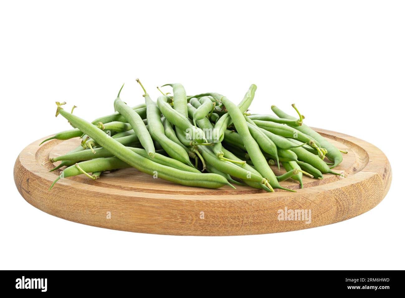 Green beans on a round cutting board isolated in white background ...