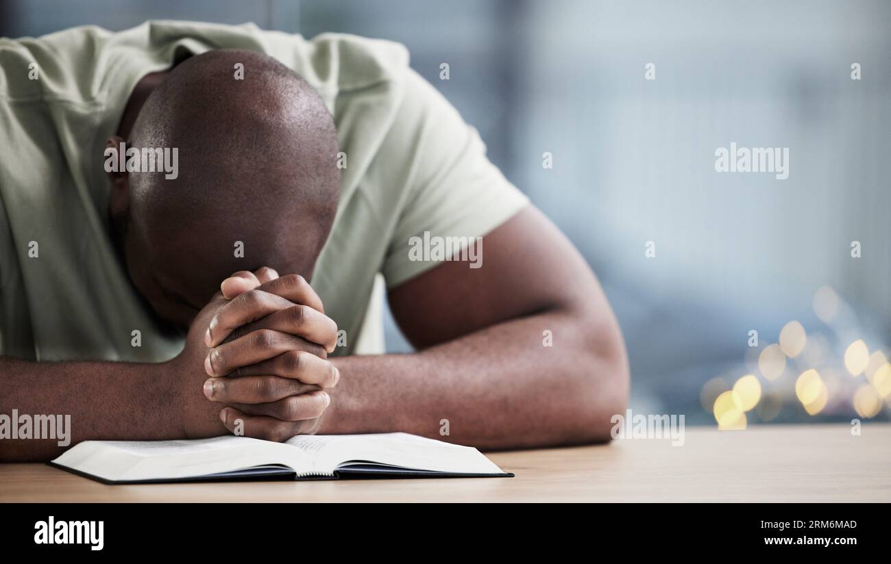 Bible, reading and man praying with book and religion study at home for ...