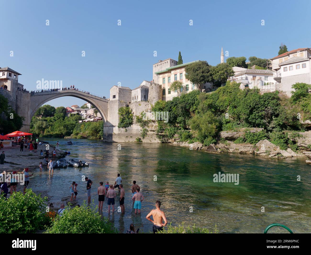 Stari Most (Old Bridge) and a beach full of tourists on the Neretva ...