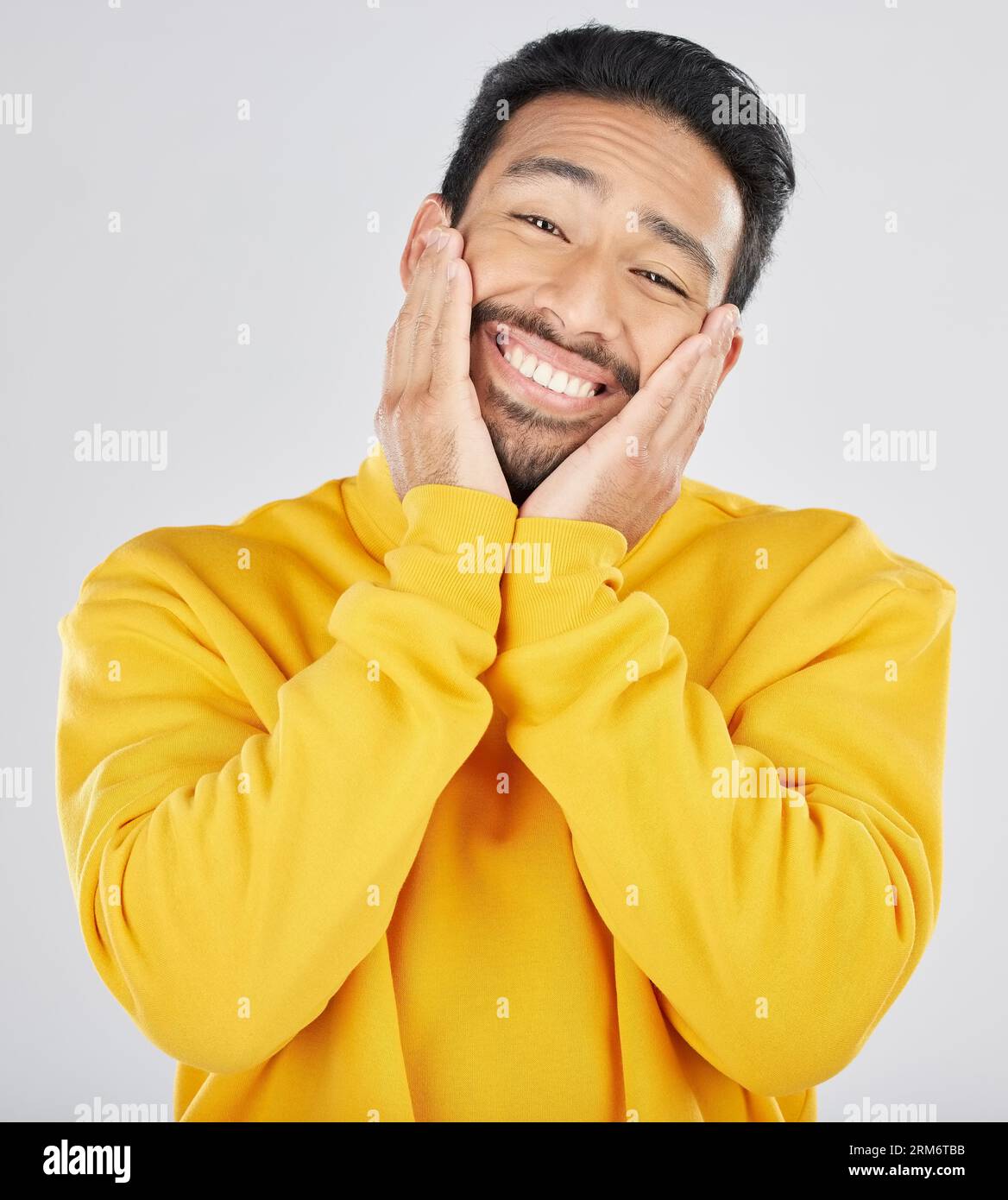Smile, shy and hands on face of asian man in studio for in love, sweet ...