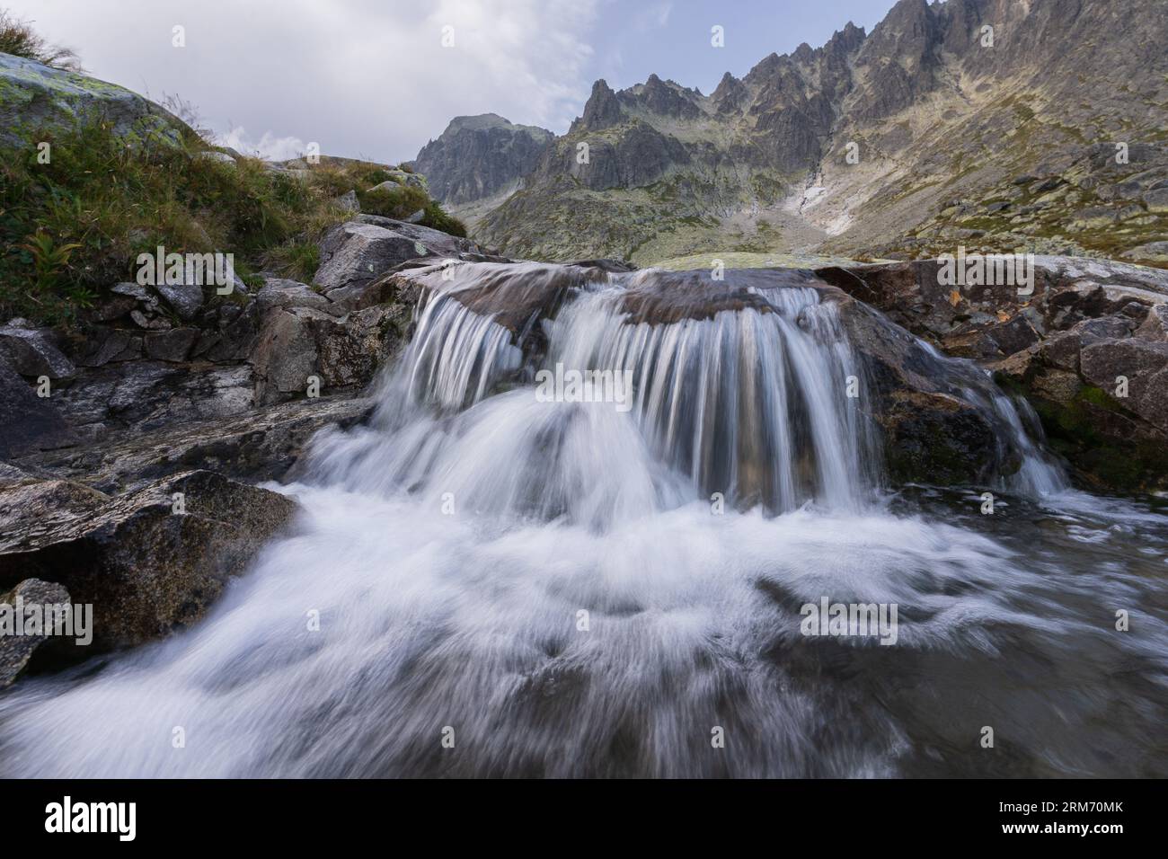 Beautiful alpine landscape with foreground waterfall and background ...