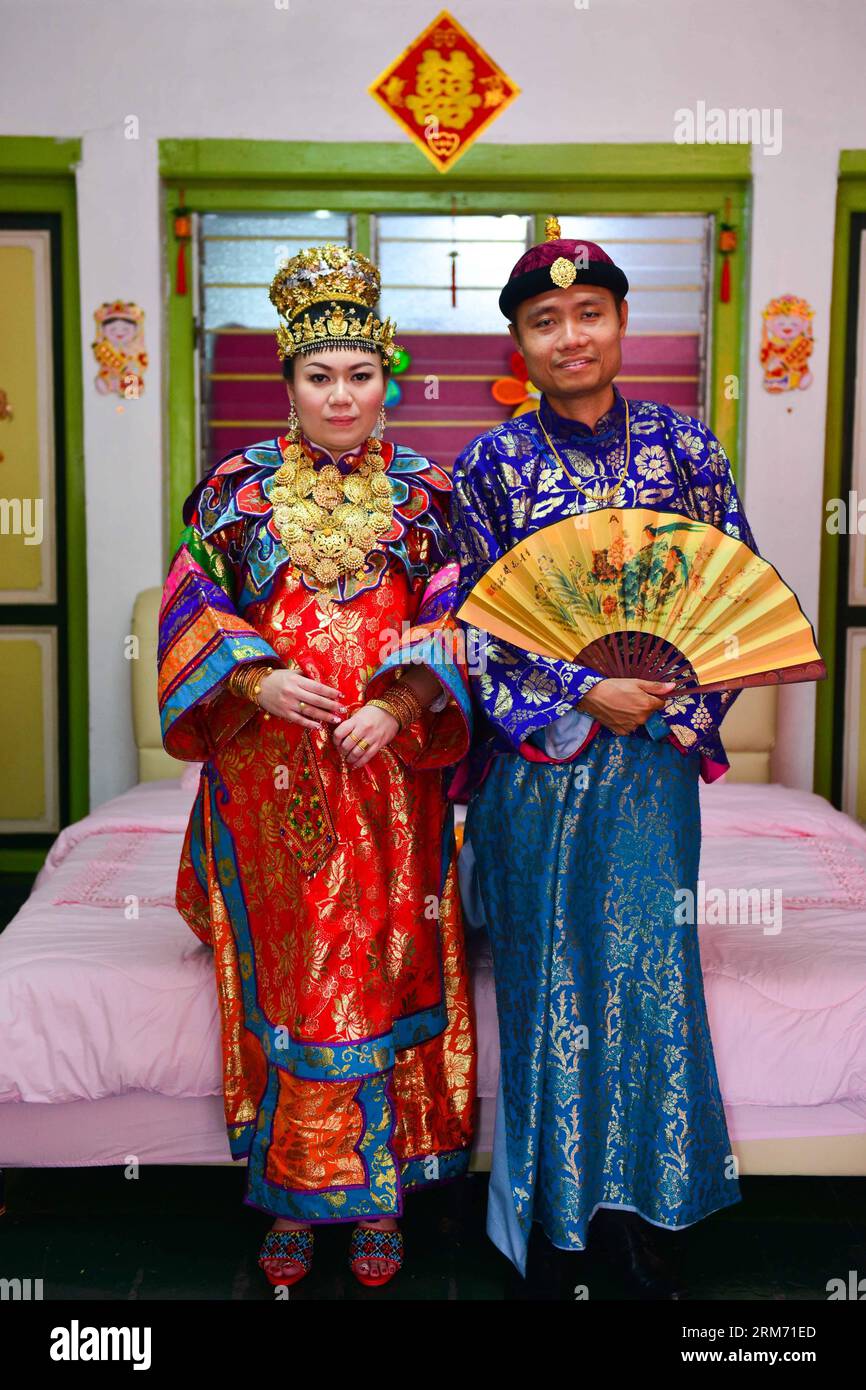 The bride and the groom pose for pictures after their Baba Nyonya ...
