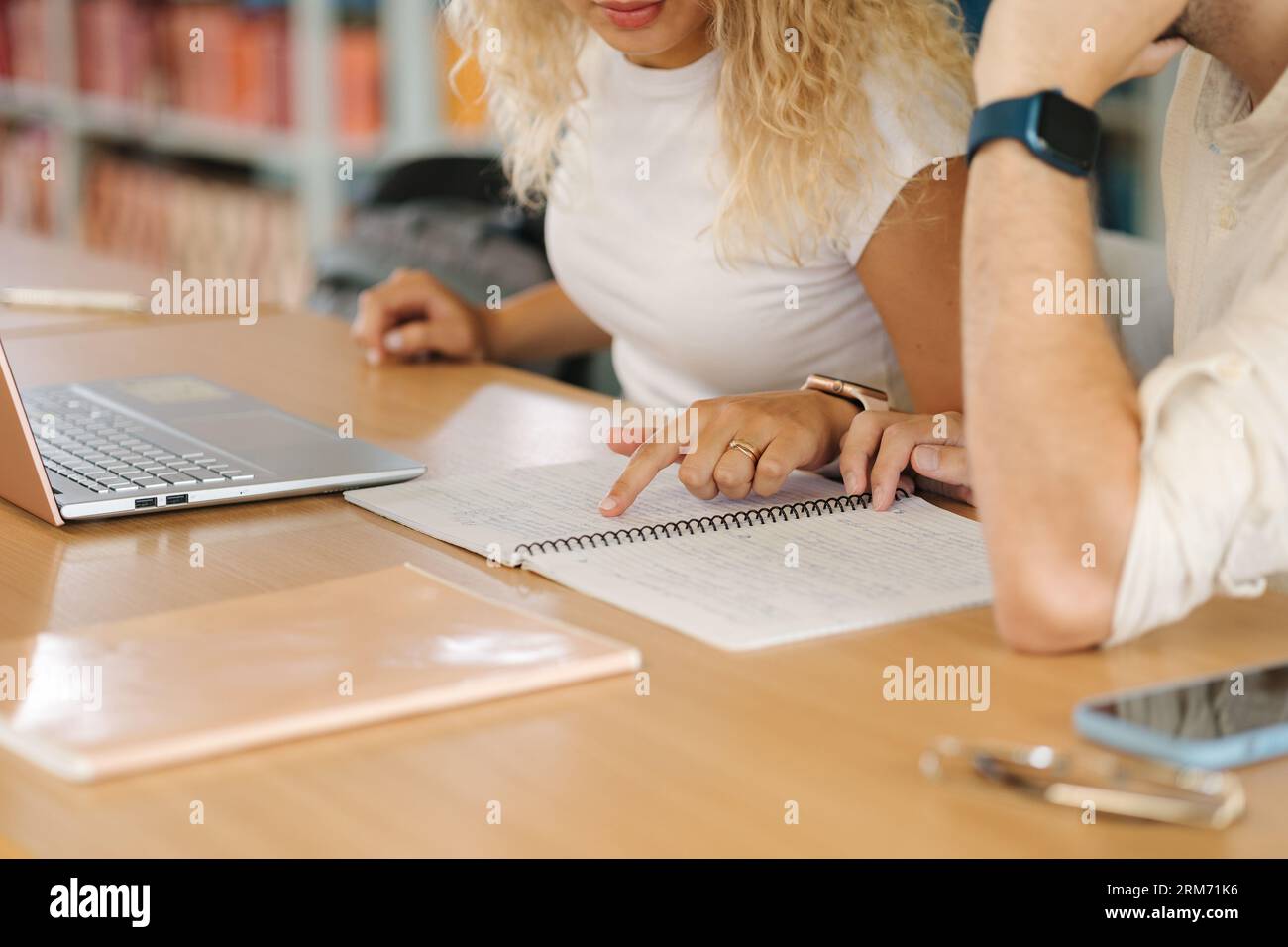 Close-up of girl show something in notebook for boy and try to type in ...