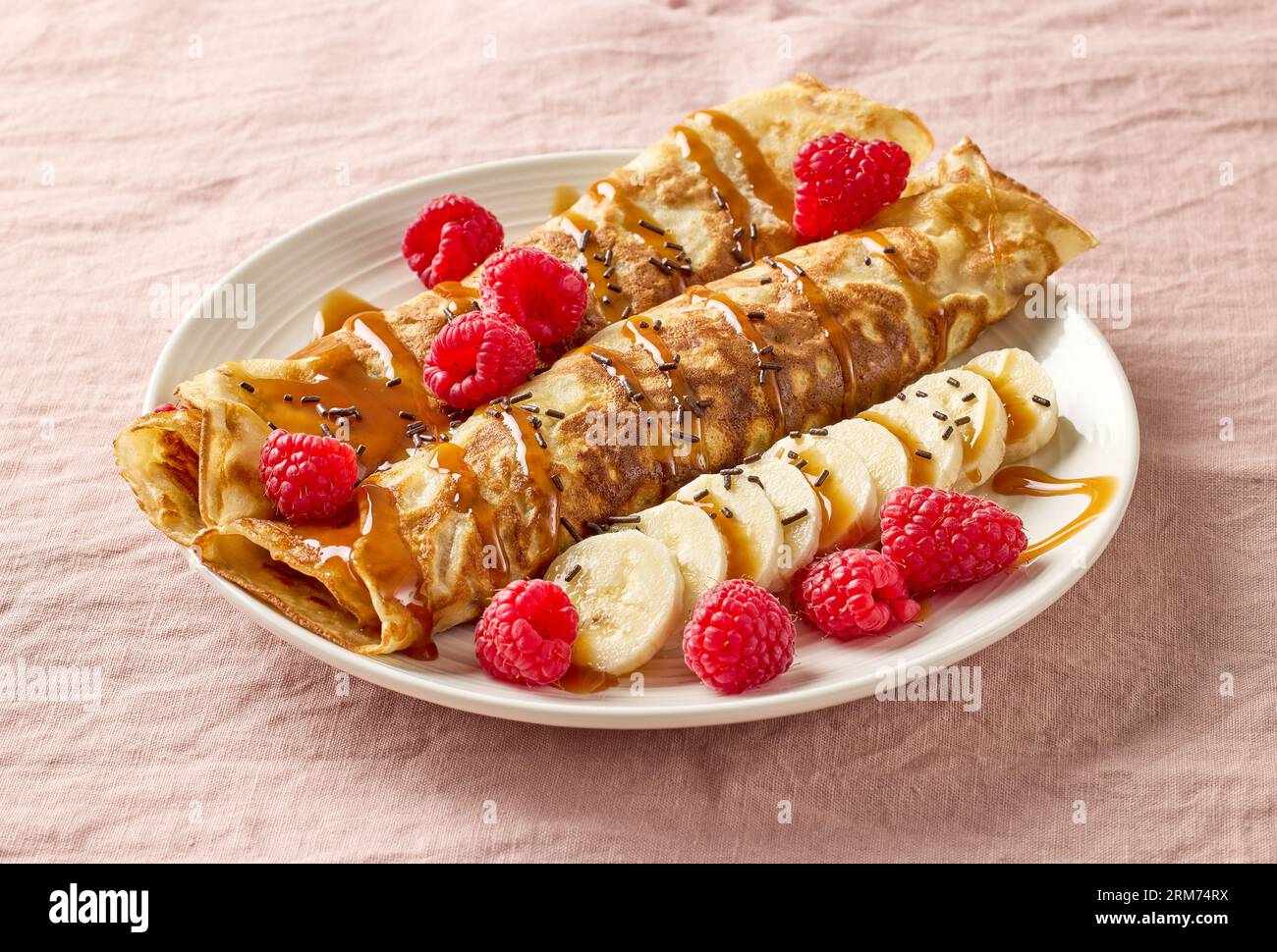 freshly baked rolled crepes with fresh fruits and caramel sauce Stock ...