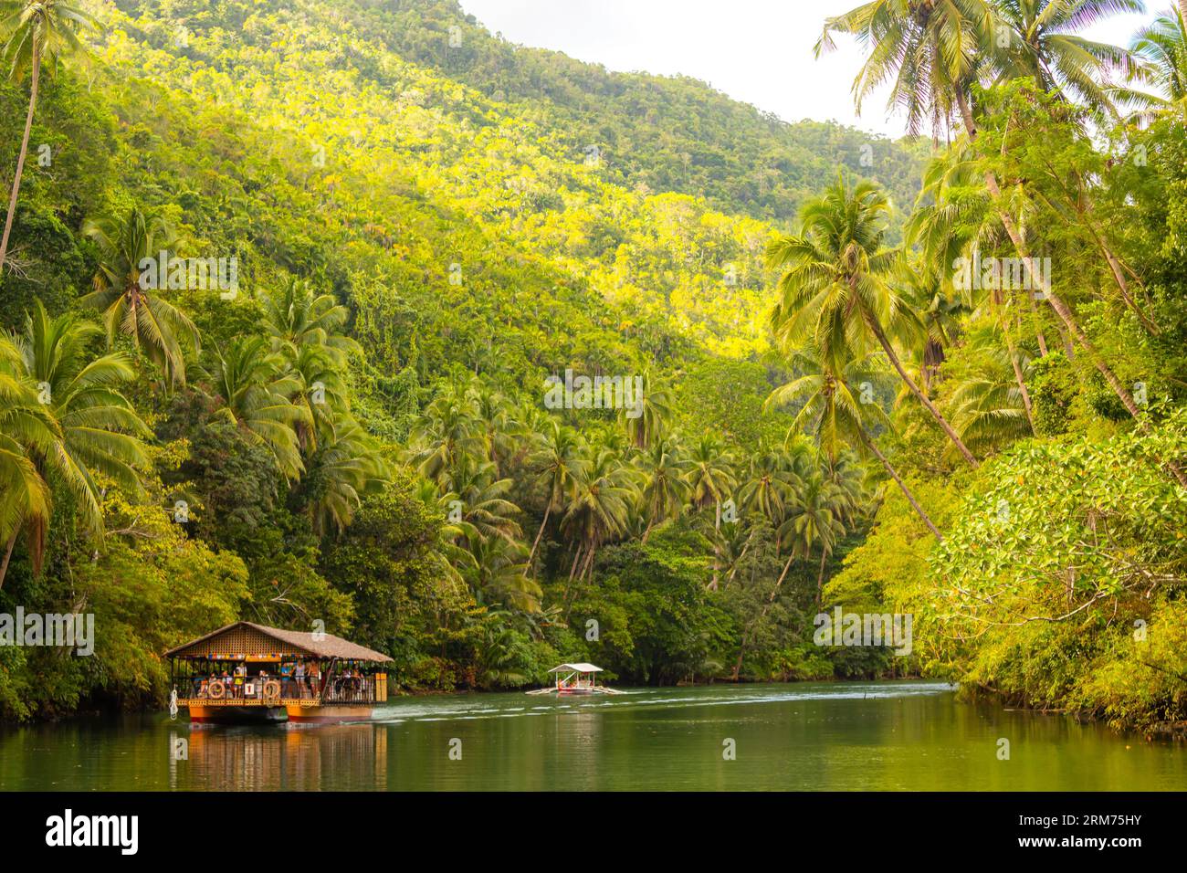 Exotic cruise boat with tourists on a jungle river Loboc, Bohol ...