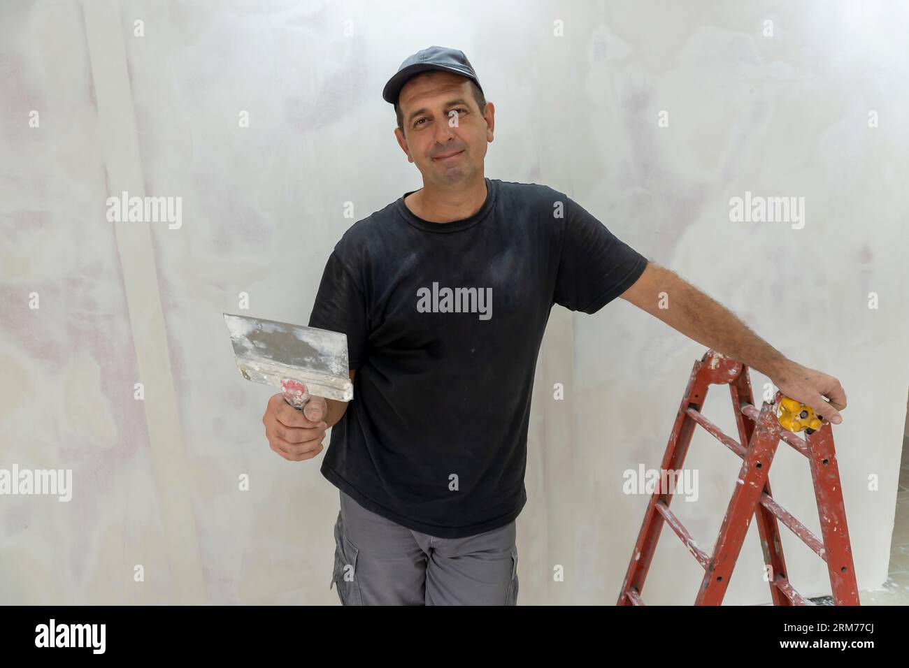 Male builder, master office, plasterer with a tool in working clothes ...