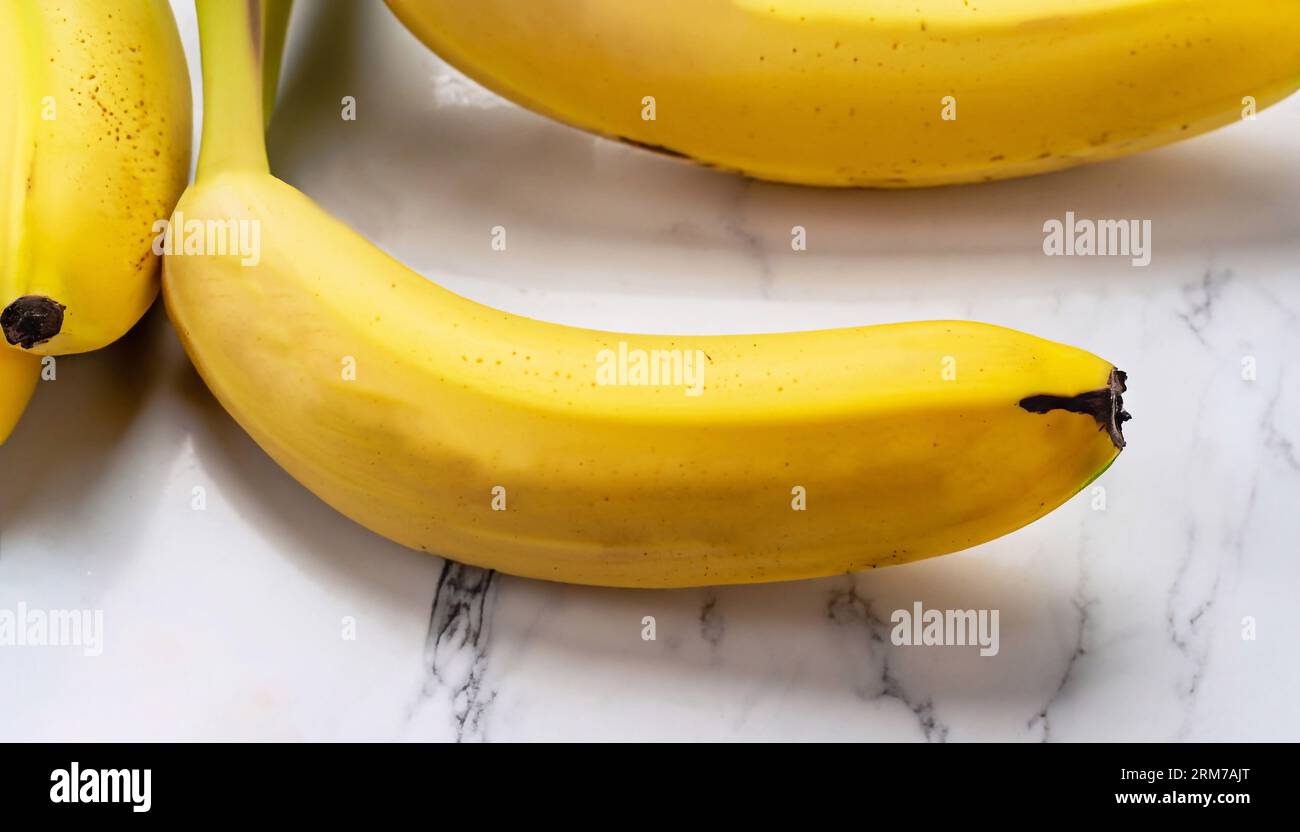 Woman's hand holding rotten, overripe bananas on white marble ...