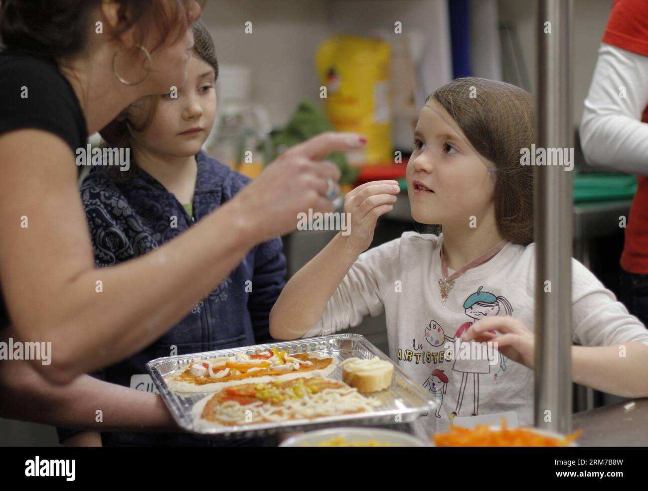 A deaf child learns how to make pizza under the help of a sign language ...
