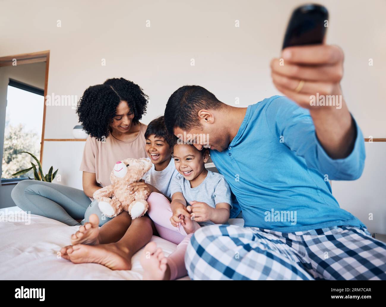 Remote control, happy family and bond in bed with television, weekend ...