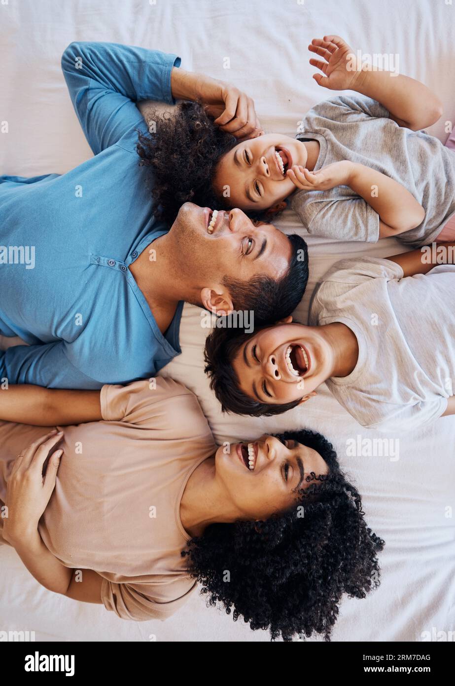 Bed, laugh and top view of children, parents or relax family humour ...